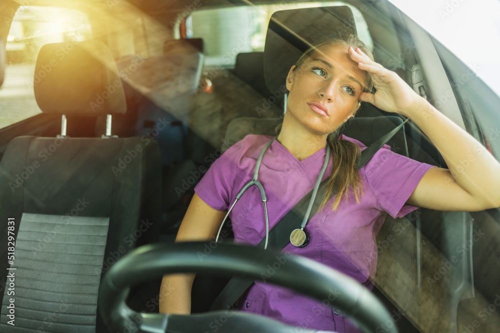 Shot of a young female doctor looking sad and tired, sitting in her car ...