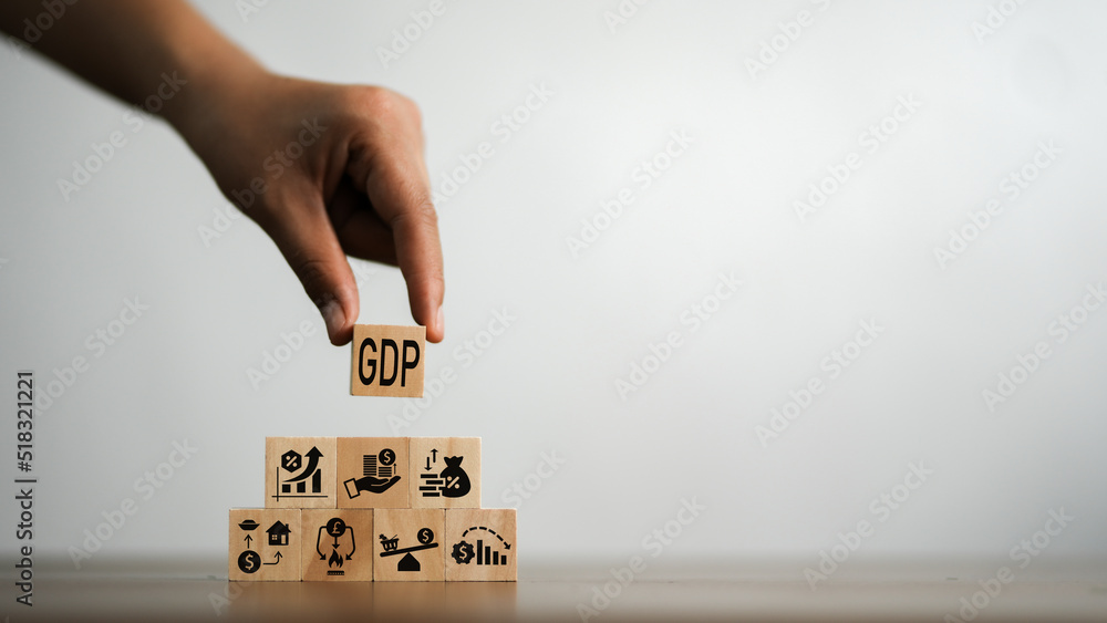 GDP, symbol of gross domestic product Businessman holding a wooden ...