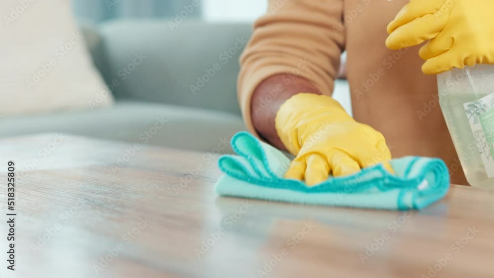 Man cleaning a table at home. Closeup of a male wiping and sanitizing a ...