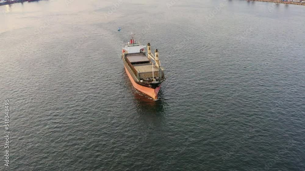Cargo rusty ship sails on the sea at sunset. A bulk carrier is a ...