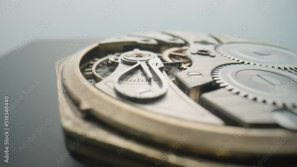 An antique pocket watch with open working clock mechanism rotates on ...