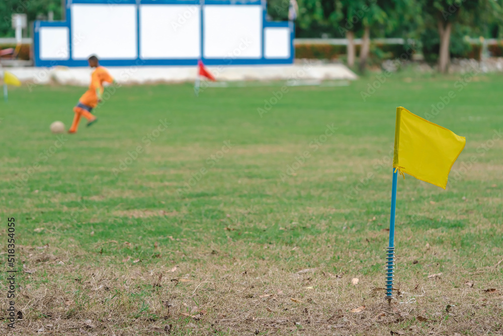 A simple yellow flag on the corner of football field in school. Place ...