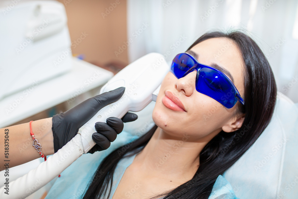 Laser hair removal procedure in a beauty salon. The master ...
