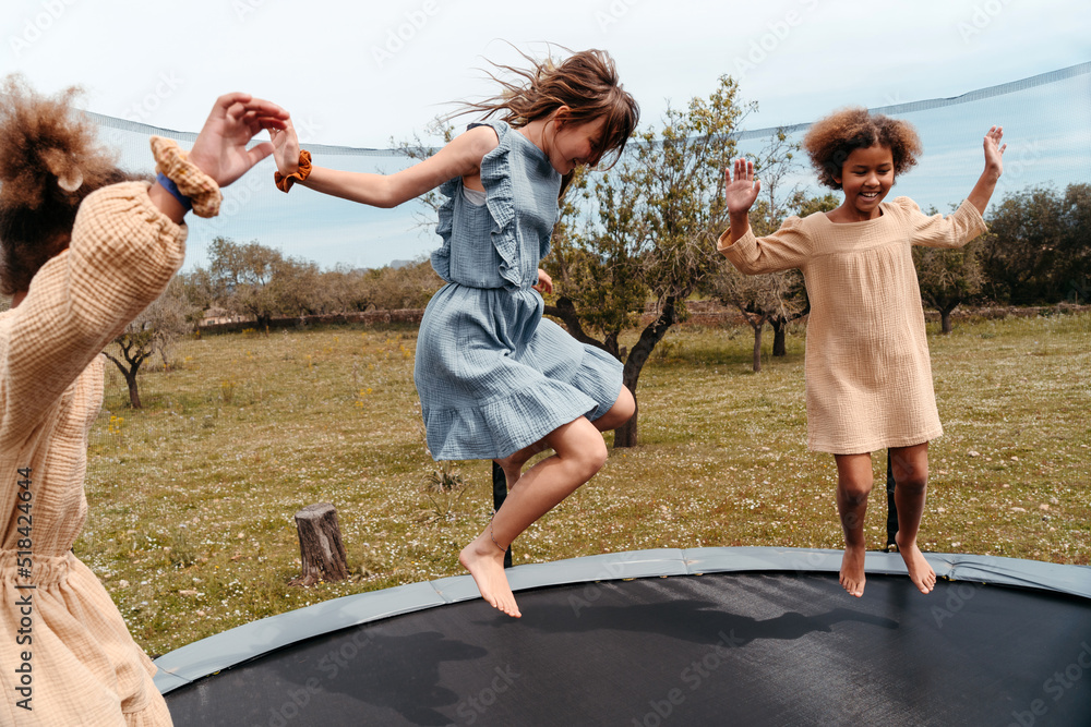 Girls playing on a trampoline Stock Photo | Adobe Stock
