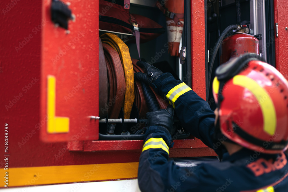 Firefighters at work pulling the hose out of the fire truck Stock Photo ...
