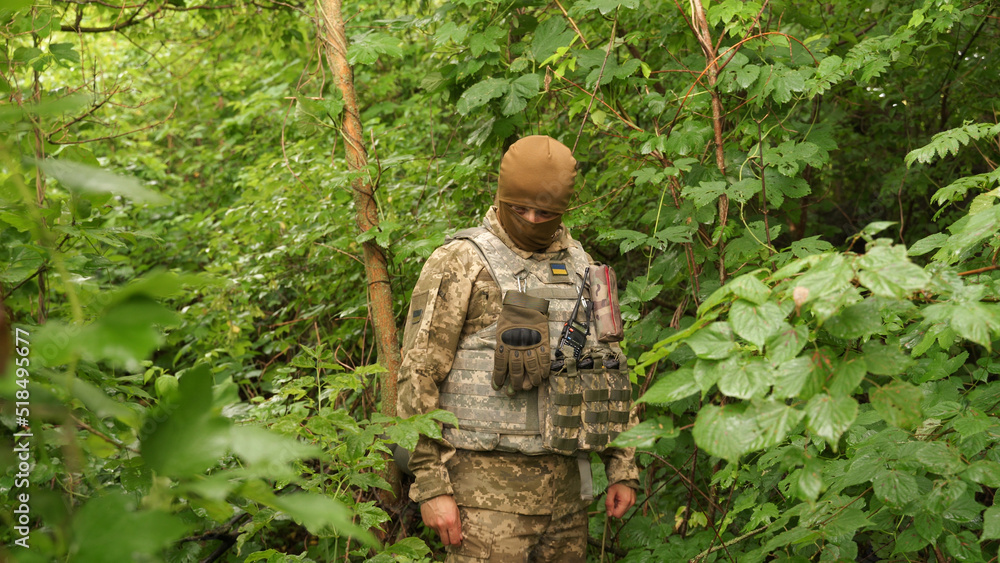 Ukrainian soldier hides from enemy attack in the forest. shelling ...