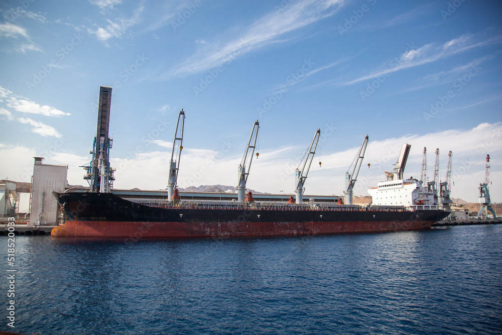 A cargo port where a laden tanker is moored. Empty cargo ship in the ...