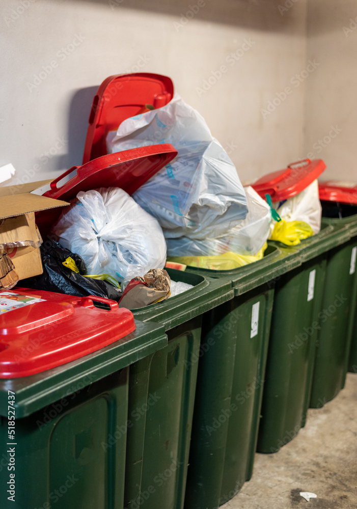 green garbage bins extremely full in an apartment building Stock Photo ...