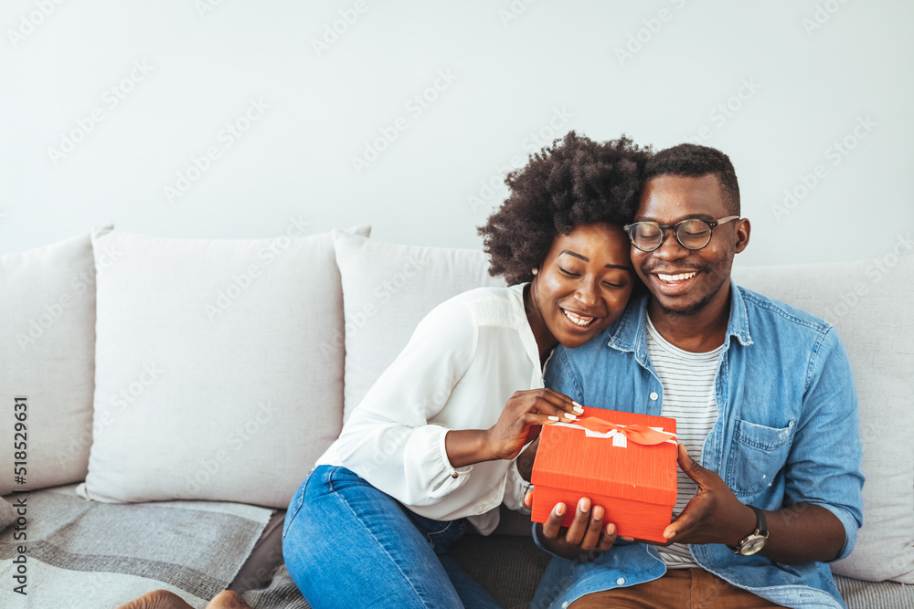 Shot of a loving husband giving his wife a gift. Boyfriend surprise his ...