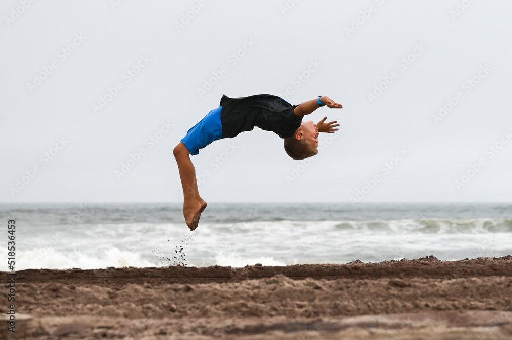 Boy Flipping on Beach Stock Photo | Adobe Stock
