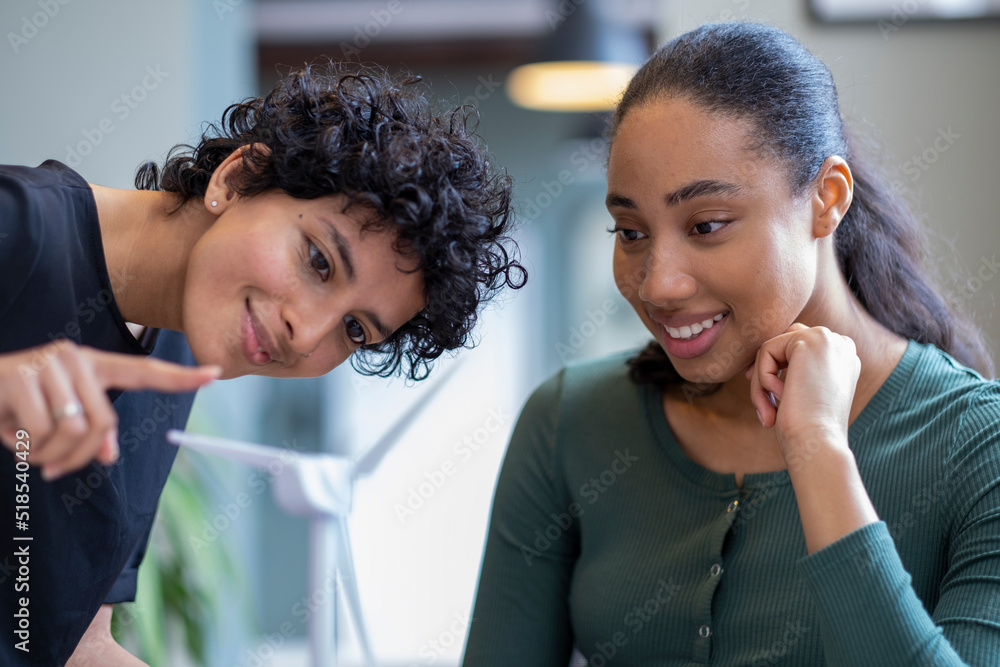 Young engineers playing with wind turbine model in office Stock Photo ...