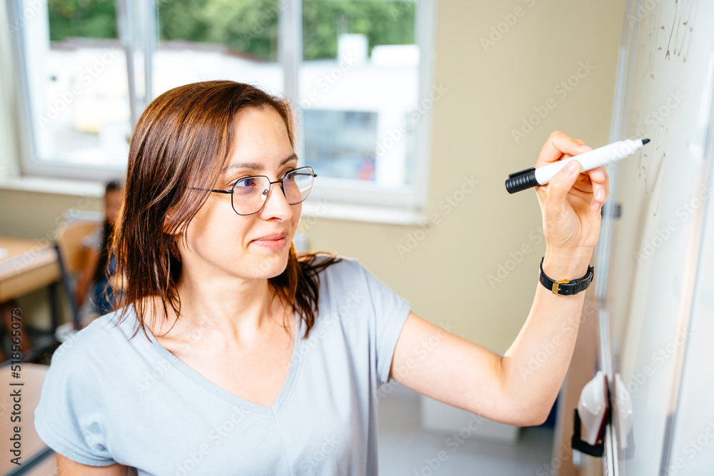 Preparing exercises. Beautiful concentrated female teacher in ...