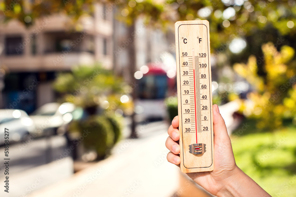 Hot weather. Thermometer in front of an urban scene during heatwave ...
