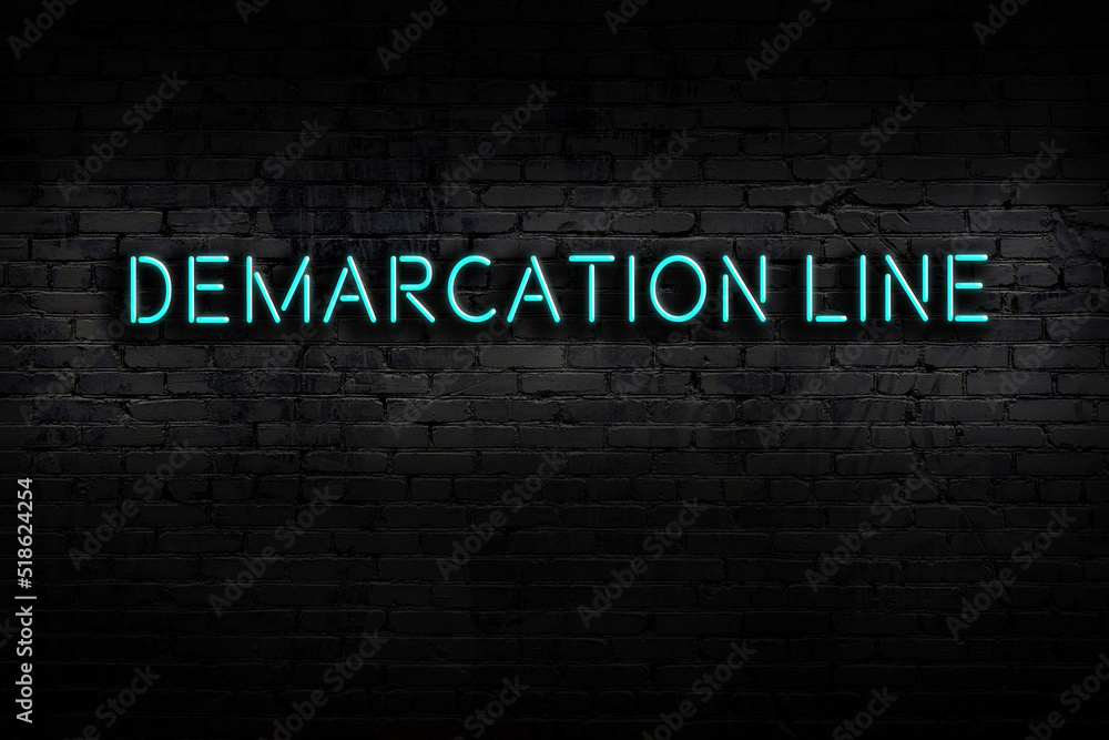 Neon sign. Word demarcation line against brick wall. Night view Stock ...
