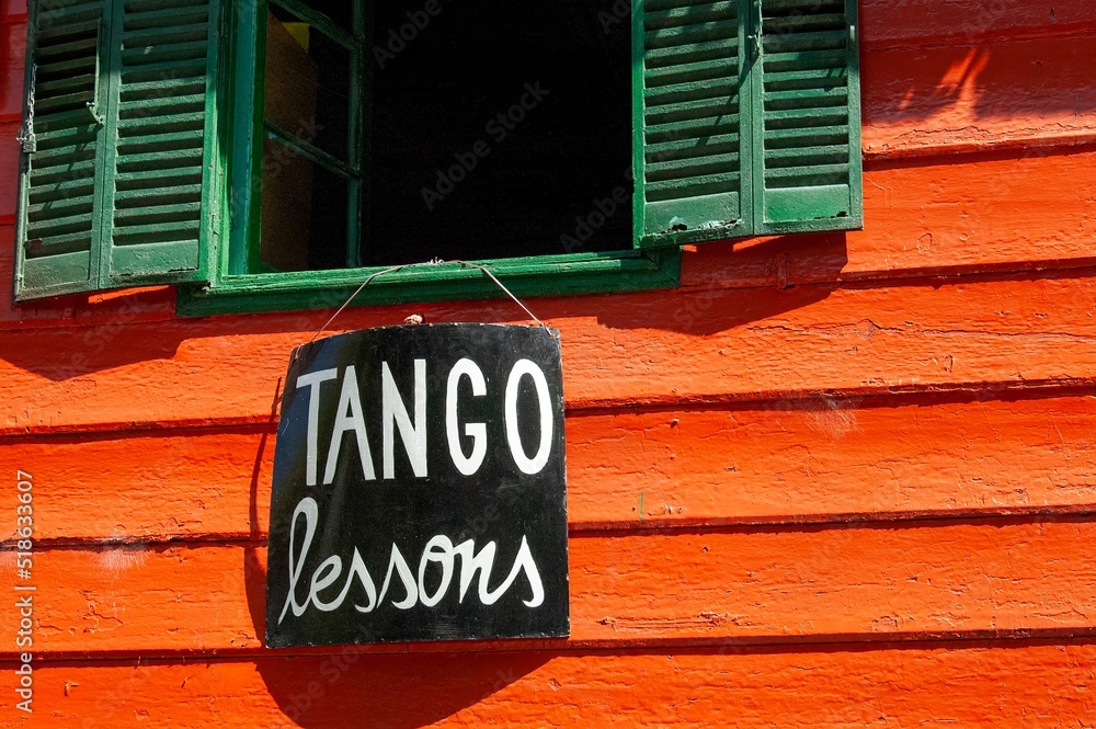 "TANGO lessons" sign hanging from an old wooden window in "La Boca ...