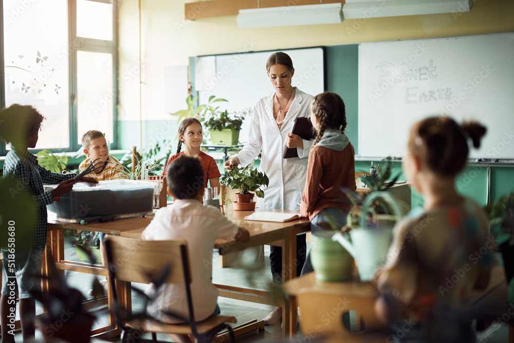 Science teacher holding botany class to group of school kids in ...