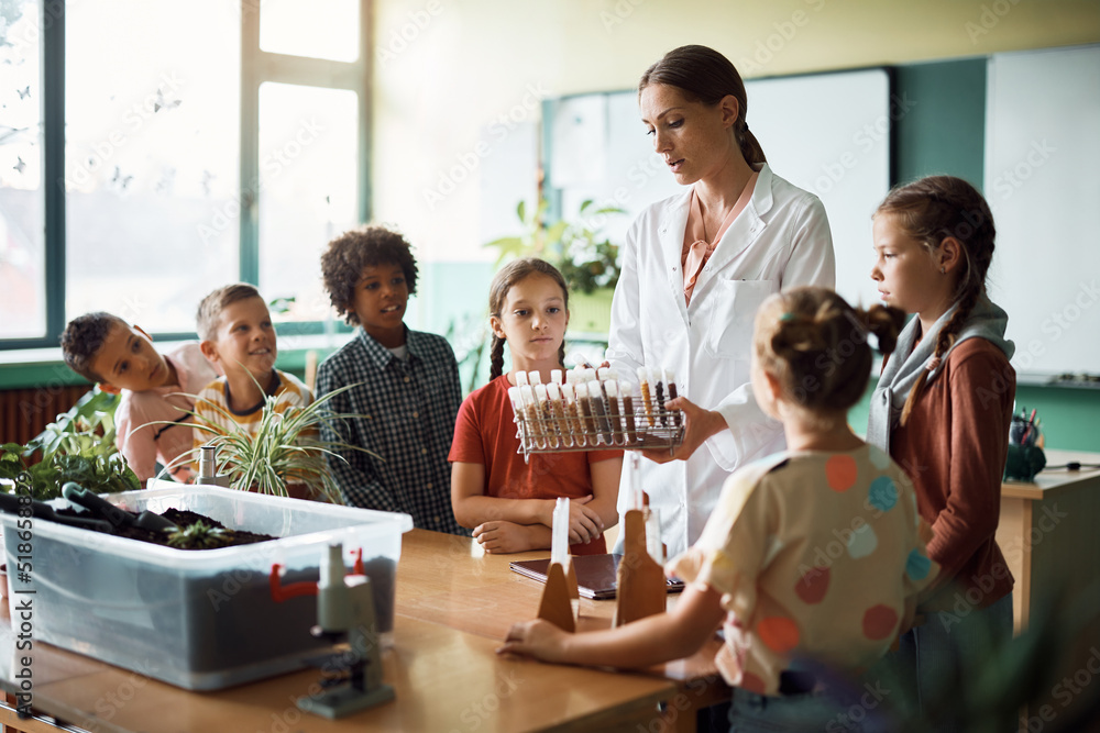 Multiracial group of school kids learning about planting seeding with ...