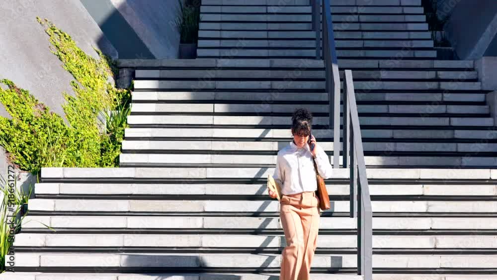 Business woman leaving work in a rush while on a phone call in the city ...
