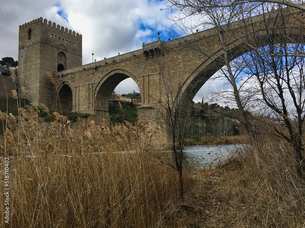 Medieval stone bridge over a river in an old city, Toledo, Spain foto ...