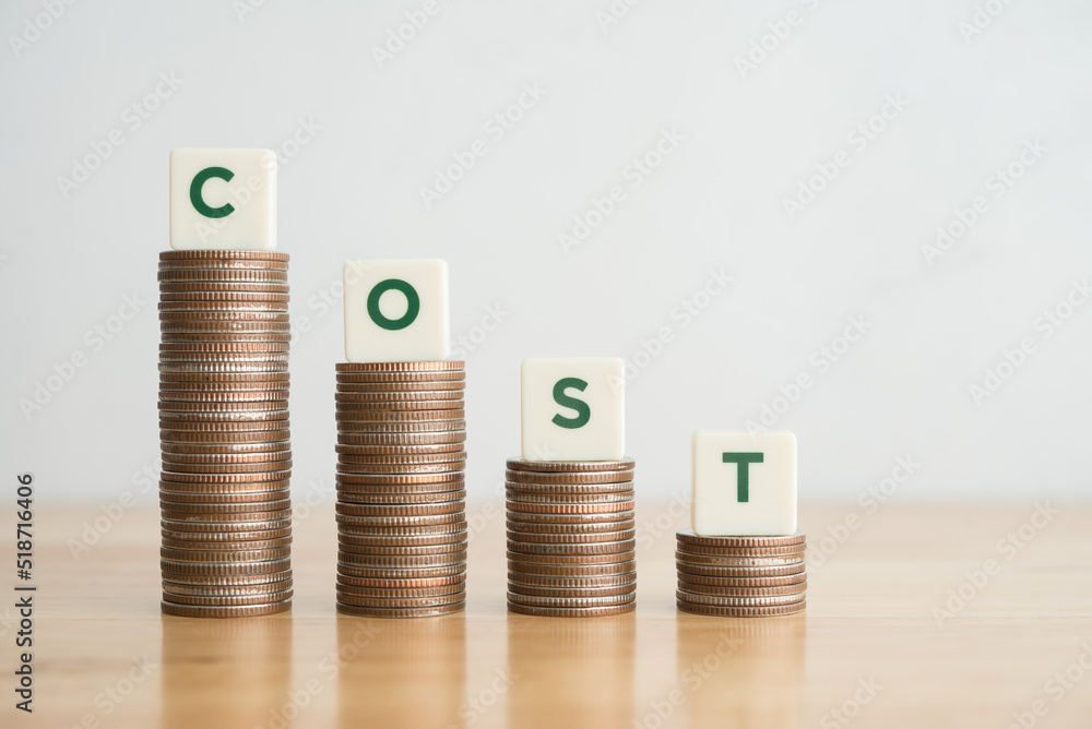 Word COST on stacks coin as graph chart falling down on wooden table ...