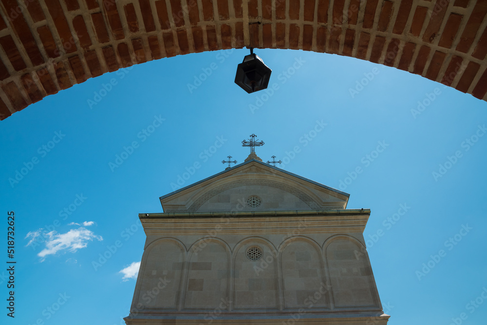 The Top Part of a Church Pictured under a Brick Arch with an Ornament ...