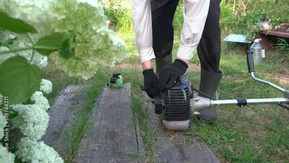 Professional starting engine for a factory gasoline lawn mower. A man ...