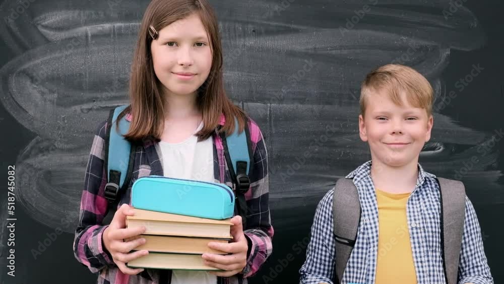 Two happy Kids on first school day on blackboard background. Cute ...