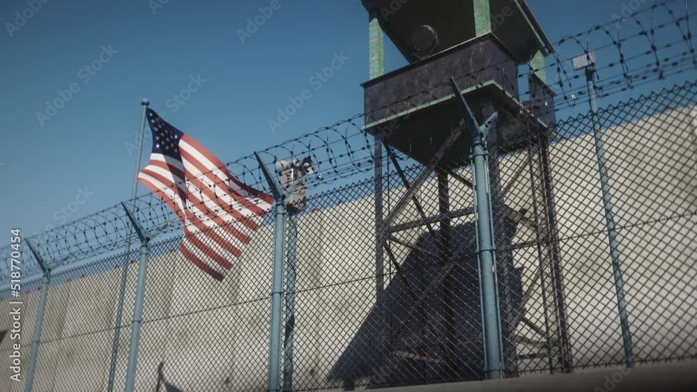 American flag above heavily guarded building, penitentiary, military ...