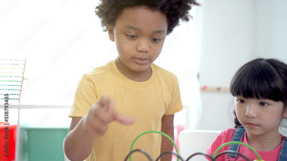 Little kindergarten kids playing together in the class, little children ...