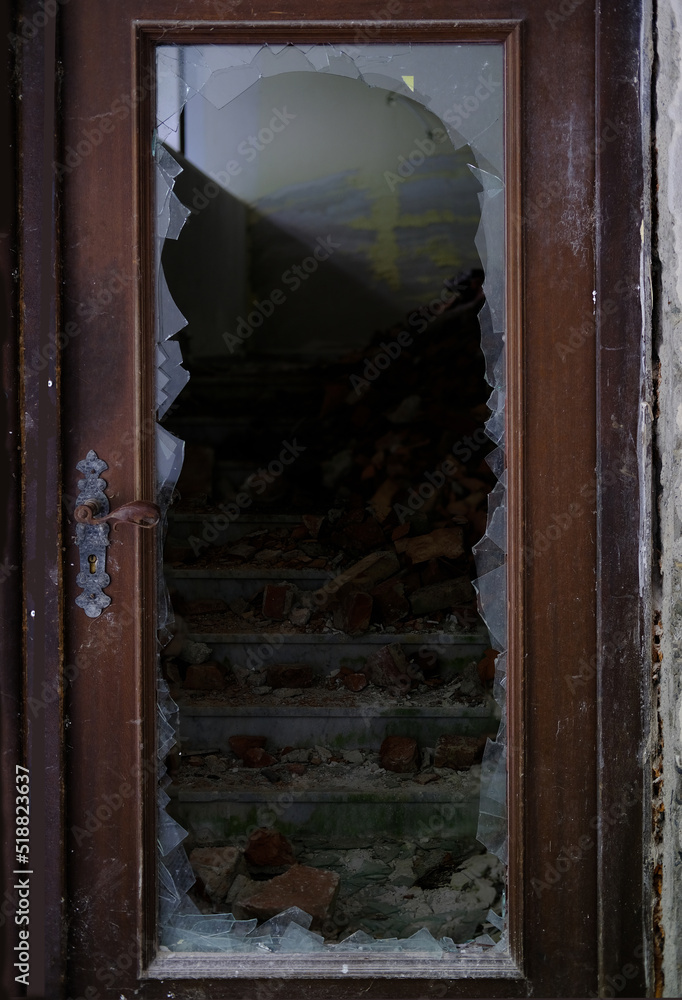dirty broken door frame with hole in center, sharp pieces of glass ...