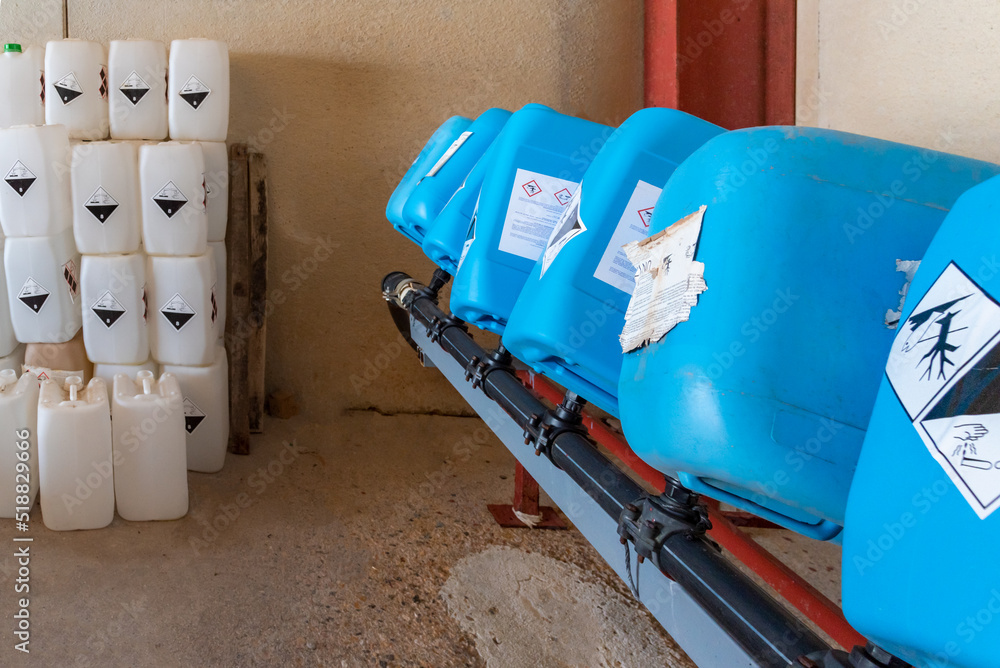 Drums with danger labels for corrosive and polluting liquids in a tank ...