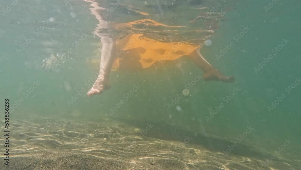 Vidéo Stock Underwater view of a female legs hanging down from a lilo ...