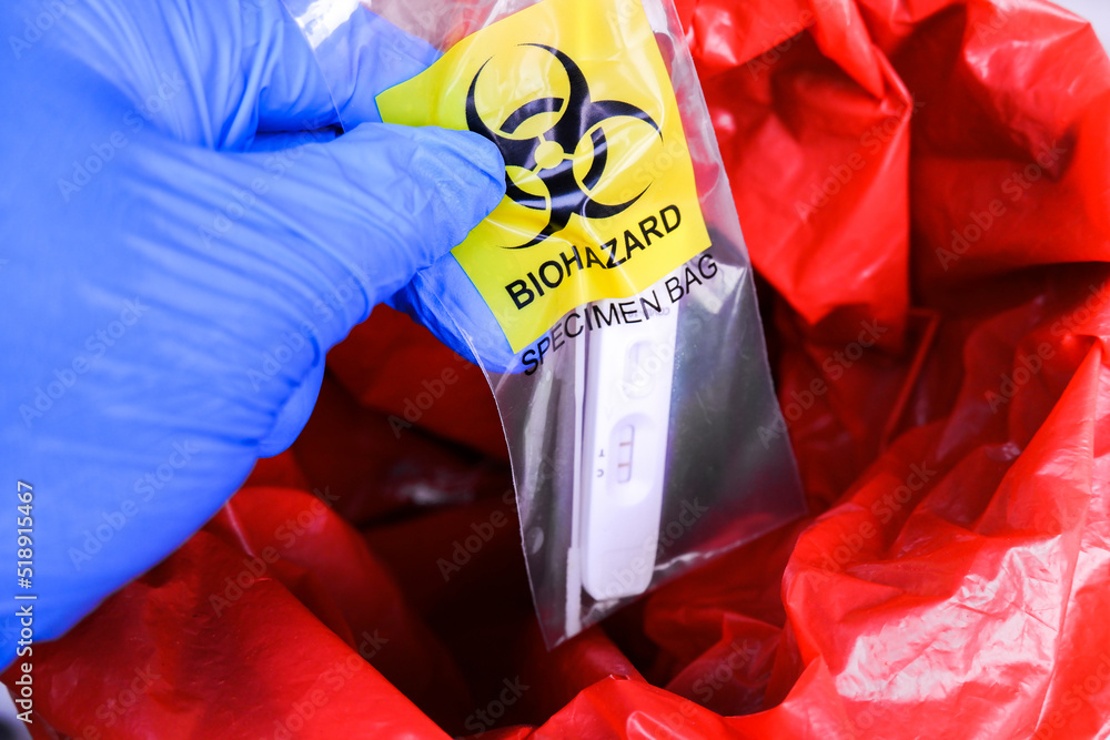 Infectious garbage of covid-19 test in biohazard specimen bag is being ...