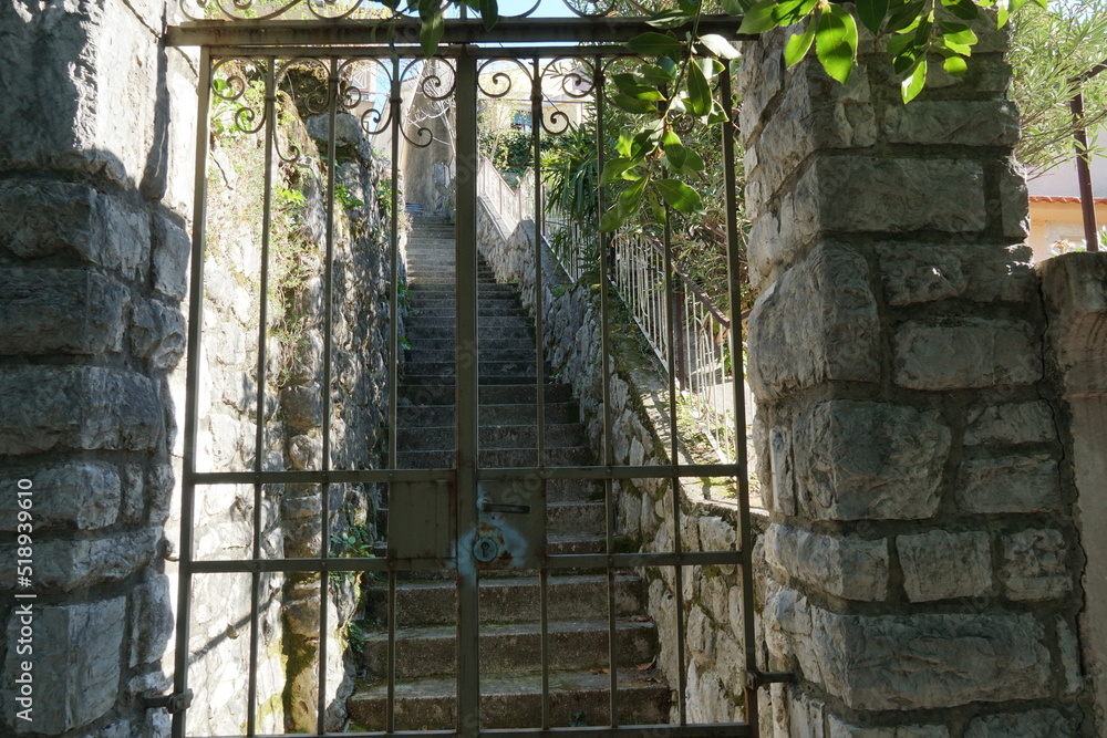 Old metal entrance gateway or gate with door lock leading to steep ...
