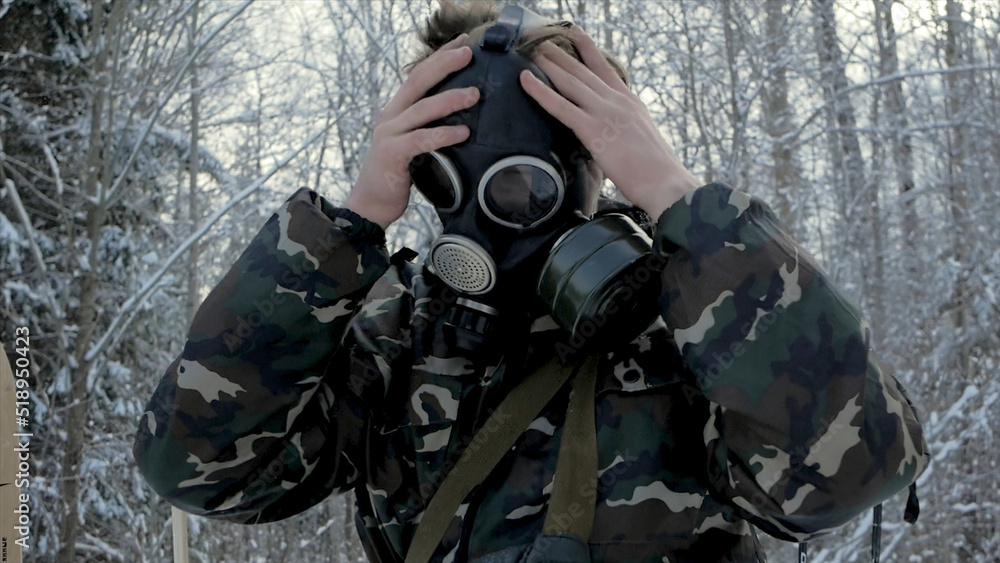 Man in uniform wearing a gas mask in the winter forest. portrait of a ...
