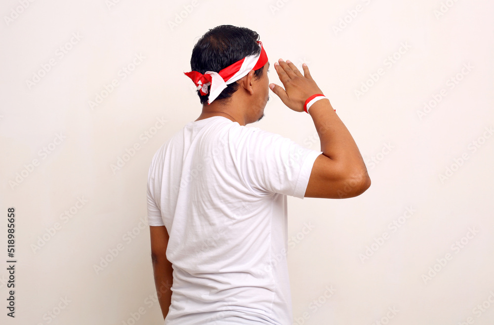 Back view of asian man standing with salute gesture. Indonesian ...