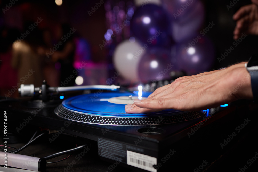 DJ behind the decks in a nightclub. DJ spinning plate. people dancing ...