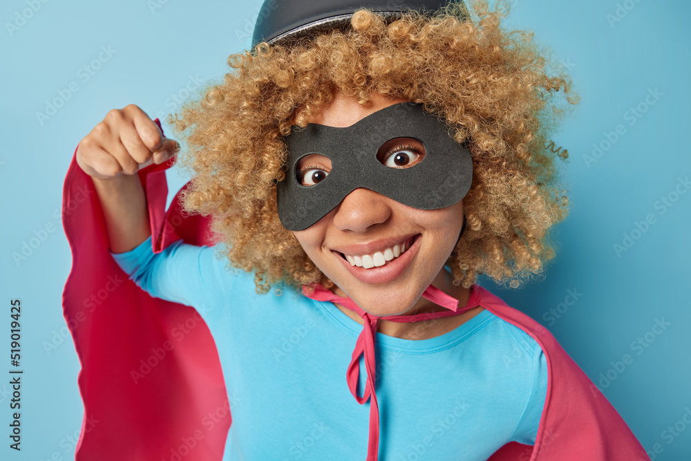 Brave cheerful young woman with curly hair clenches fist wears black ...