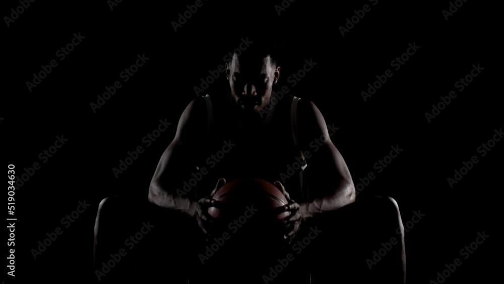 Basketball player sitting on a bench taking deep breath in ...