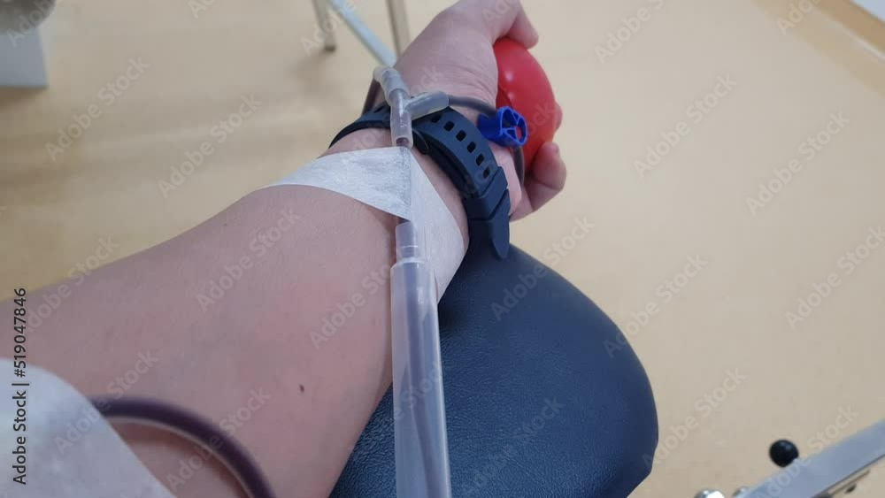 Blood donation, left hand pumping the red color ball for faster blood ...