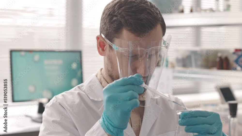 Chest up slowmo of Caucasian male scientist in lab coat, gloves and ...