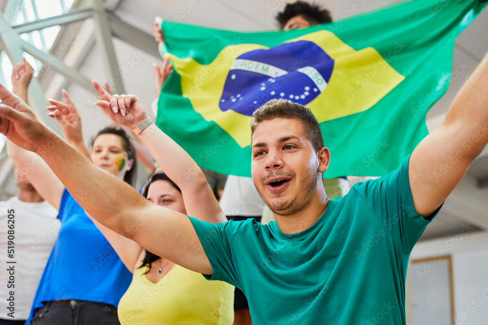 Man with arms raised cheering with fans at sports event in stadium ...