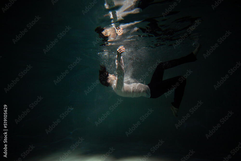 Beautiful underwater shooting, guy in white shirt and pants has fallen ...