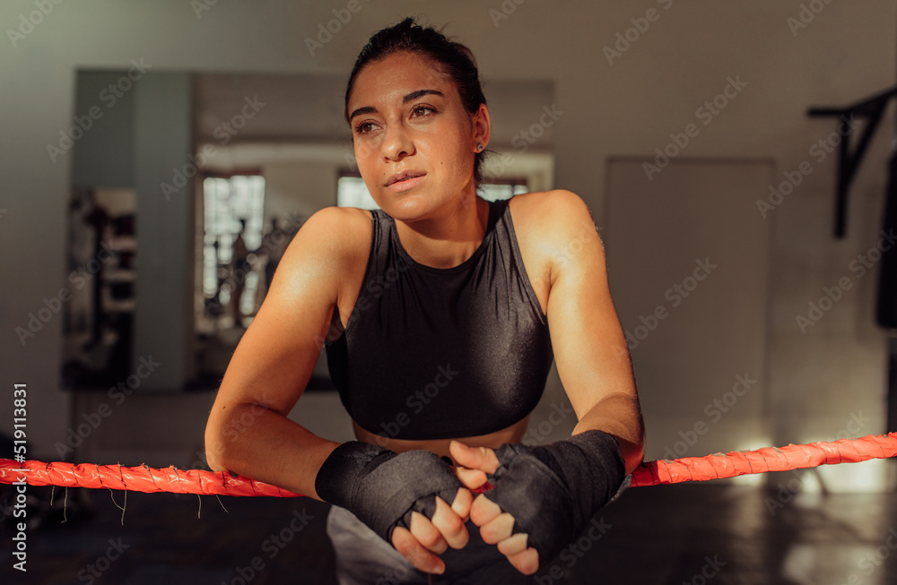 Thoughtful female boxer leaning on boxing ring ropes Stock Photo ...