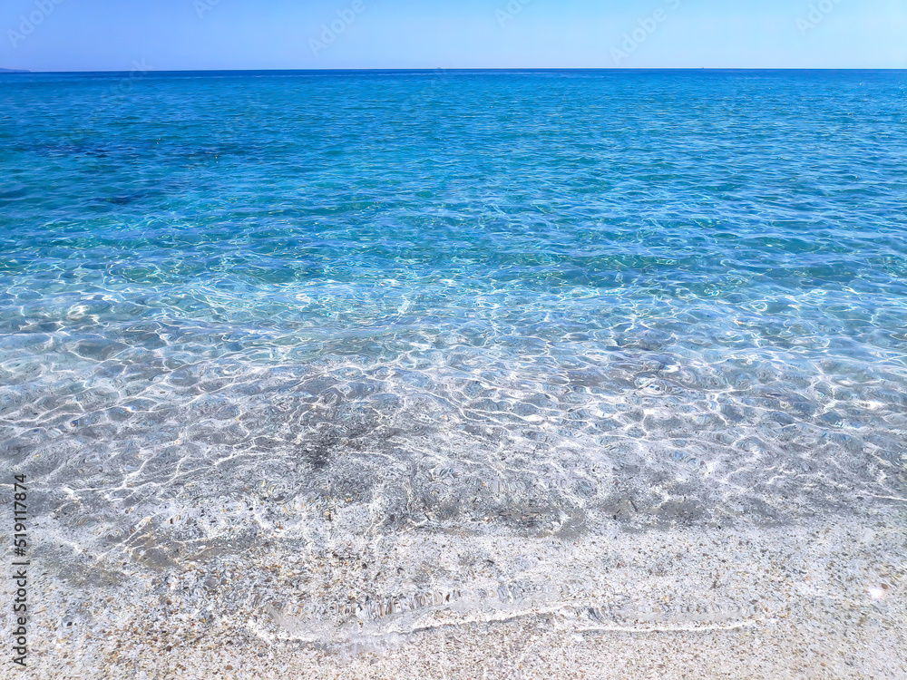 Spiaggia in riva al mare con acqua limpida Stock Photo | Adobe Stock