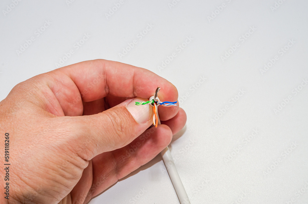 A computer wizard strips the wires of an Internet cable for connecting ...