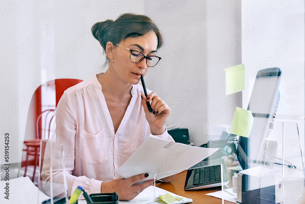 Attentive female bookkeeper check accounts bills. Middle-aged woman ...