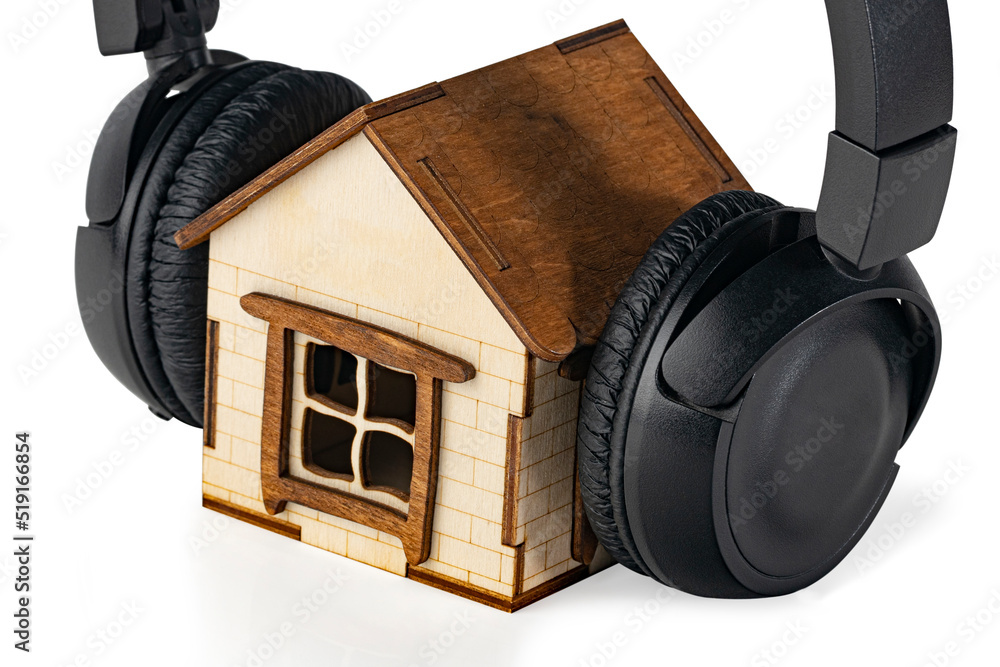 Black wireless headphones on a small wooden house close up isolated on ...