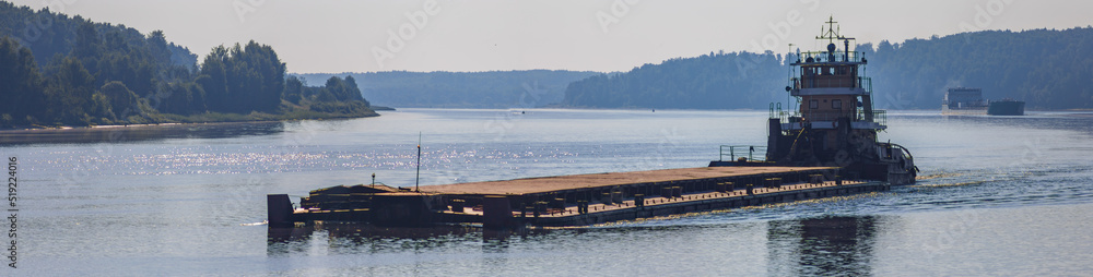 A large cargo barge transports cargo by river to the main port for ...