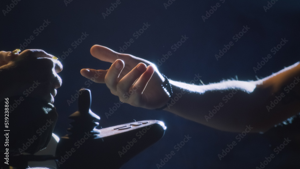 An actor on a dim stage giving a hand to an actress with disability in ...